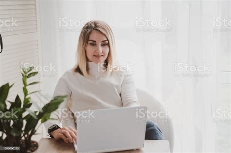 직장에서 앉아있는 동안 노트북과 휴대 전화를 사용하여 즐거운 매력적인 여성 40 44세에 대한 스톡 사진 및 기타 이미지 40 44세 Brand Name Smart