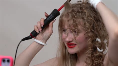 A Woman Styles Hair Using A Curling Wand Manual Wrapping Of Long Hair Around The Wand To Create