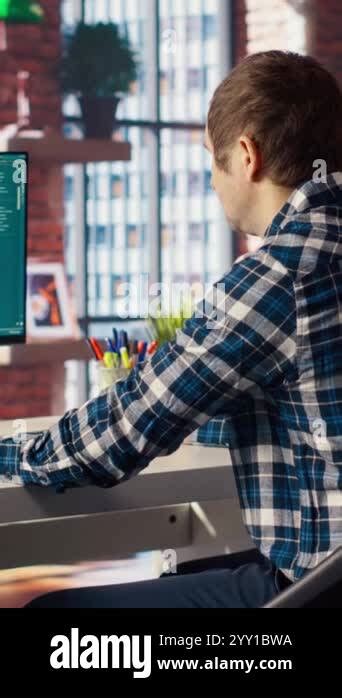 Man Seated At Desk Using AI LLM Chatbot Software In Modern Urban Home