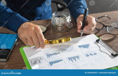 Man Holding Magnifying Glass With A Graphs And Charts Business Stock