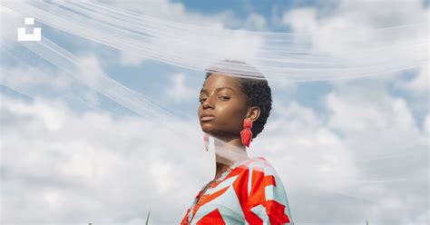 흰색 빨간색과 파란색 꽃무늬 긴 소매 셔츠를 입은 여자가 푸른 잔디밭에 서 있다 사진 Unsplash의 무료 유행 이미지