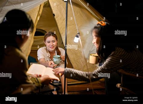 A Group Of An Asian Female Teenagers Enjoy Camping And Talking At Night