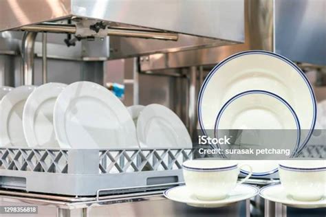 주방 룸 레스토랑에서 청소를위한 자동 식기 세척기 기계에 접시 컵 세트와 바구니에 많은 흰색 접시 레스토랑에 대한 스톡 사진 및