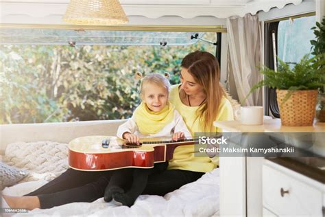 교사는 아이 기타 연주와 노래를 르 친다 아름 다운 젊은 어머니와 딸 아늑한 캠핑에서 휴식 가족에 대한 스톡 사진 및 기타