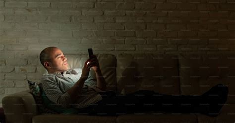 집에서 소파에 누워 밤에 스마트폰을 보고 있는 백인 남성의 프로필 보기 사진 Unsplash의 가정 생활 이미지