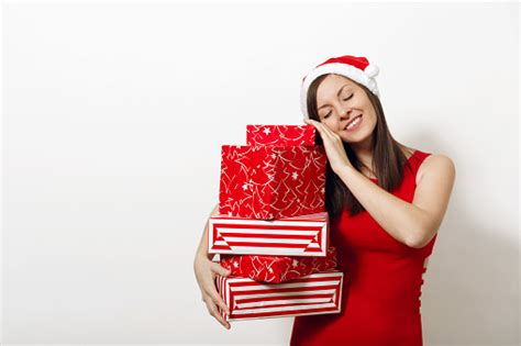 매력적인 미소와 아름 다운 백인 젊은 행복 한 여자 입고 빨간 드레스와 흰색 바탕에 선물 상자를 들고 크리스마스 모자 현재 격리와 산타 소녀입니다 새 해 휴일 2018 개념