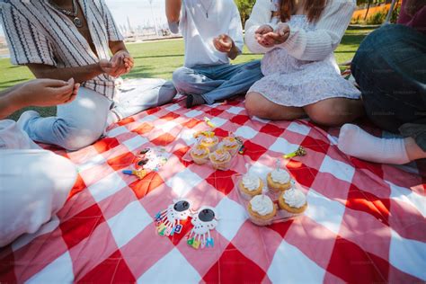 빨간색과 흰색 체크 무늬 테이블 천 위에 앉아있는 한 무리의 사람들 사진 Unsplash의 피크닉 이미지