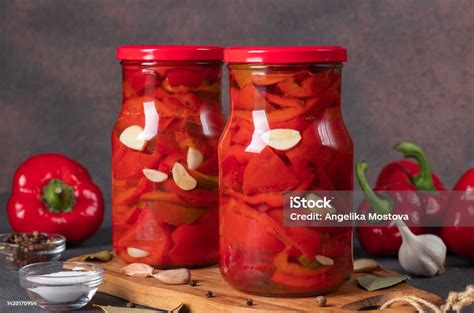 갈색 배경에 두 개의 유리 병에 마늘을 곁들인 절인 달콤한 고추 정면 전망 가을에 대한 스톡 사진 및 기타 이미지 가을 갈색 건강한 생활방식 Istock