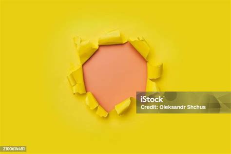 분홍색 빈 배경이 있는 노란색 종이에 찢어진 구멍 복사 공간 모형 텍스트 또는 로고를 위한 위치입니다 금이 간에 대한 스톡 사진