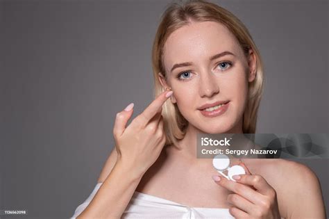 자연 메이크업과 손에 접촉 눈 렌즈와 젊은 아름 다운 여자의 초상화 흰색 렌즈 상자를 들고 여성 모델의 클로즈업 눈 신체 부분에