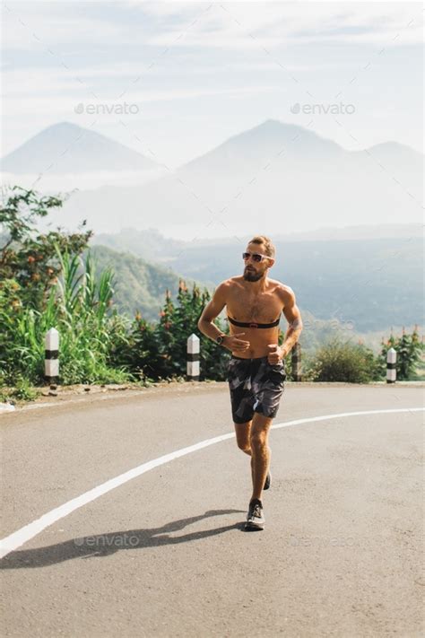 Man Running Topless In Uphill On The Asphalt Road In Hot Summer Weather