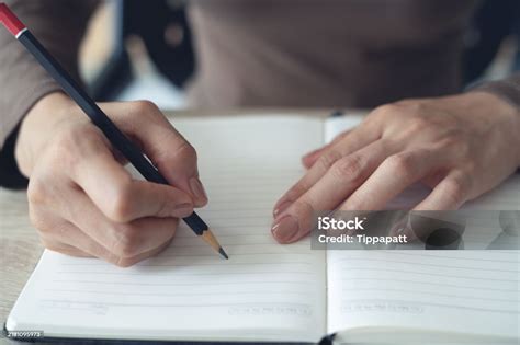 클로즈업 사무실 탁자 위의 종이 공책에 글을 쓰는 연필을 가진 여자의 손 비즈니스 여성은 알림 메모장 비즈니스 및 이벤트 계획 앞보기에 대한 아이디어를 메모합니다 계획에