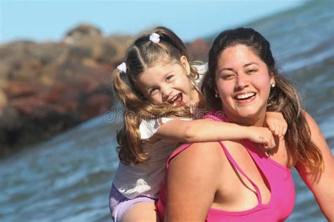 Young Cheerful Latino Woman And Her Little Daughter At The Beach On