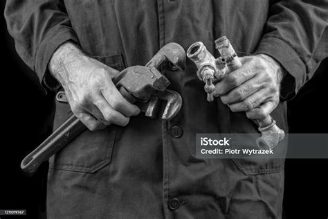 렌치와 오래된 파이프를 들고 앞치마에 배관공 빌더용 액세서리 및 부품 어두운 배경 건설 기계류에 대한 스톡 사진 및 기타 이미지 건설 기계류 건설 산업 관 튜브