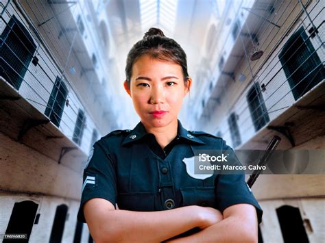 범죄 처벌과 법 집행 개념에서 경찰 유니폼을 입고 국가 교도소 감옥에 서 서 젊은 심각 하 고 매력적인 아시아 중국 가드 여자의 초상화 경찰관에 대한 스톡 사진 및 기타