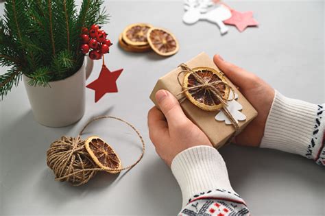 수컷 손은 공예 용지에 싸여 크리스마스 선물 상자를 잡고 있습니다 회색 텍스처 배경입니다 공예에 대한 스톡 사진 및 기타 이미지 Istock