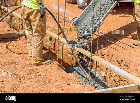 Concrete Vibrator Being Used By Construction Worker In Order To Compact Concrete Into Trenches