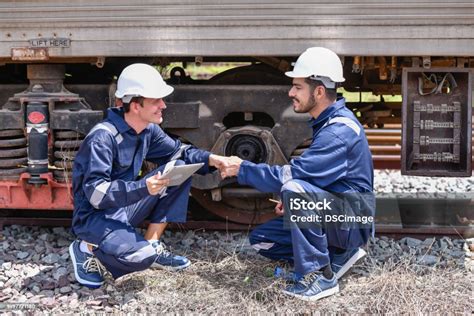 건설 과정을 점검하는 엔지니어 철도 열차 테스트 및 무선 통신으로 철도 역에서 철도 작업을 점검합니다 직장에서 안전복과 안전 헬멧을 착용한 엔지니어 2명에 대한 스톡 사진