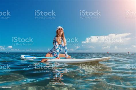 Sup 스탠드 업 패들 보드 맑은 물로 아름다운 잔잔한 바다에서 항해하는 젊은 여성 여름 방학 여행 휴식 자연과 조화를 이루는 활동적이고 건강한 삶의 개념 건강한 생활방식에