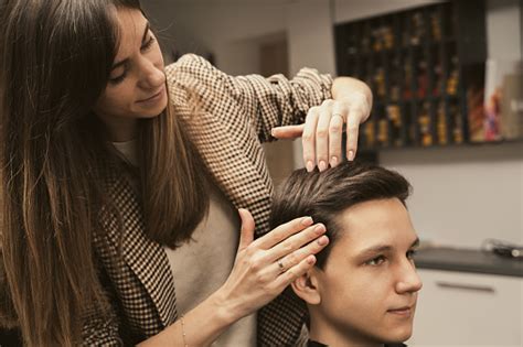 미용실 마스터는 이발소에서 헤어 스타일링 클라이언트를합니다 남성의 패션과 스타일 헤어 케어 뷰티 산업 이발소 개념 이발소 남자 헤어 스타일 현대 이발을 얻는 젊은 남자 머리