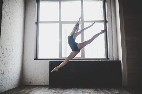 가소성 슬림 한 여자는 창 근처에서 춤을 추고 있습니다 전문 댄서가 춤을 즐깁니다 클래스에서 레이디 댄서 훈련 현대 발레 현대 무용 연기자 일광 실루엣 아름 다운 몸 댄스