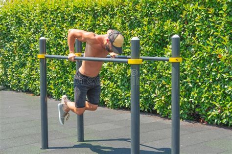 Young Caucasian Man Naked Torso And Dark Shorts And A Cap Trains Doing