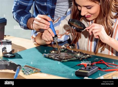 Man Helping Woman Soldering Elements Of Circuit Board Stock Photo Alamy
