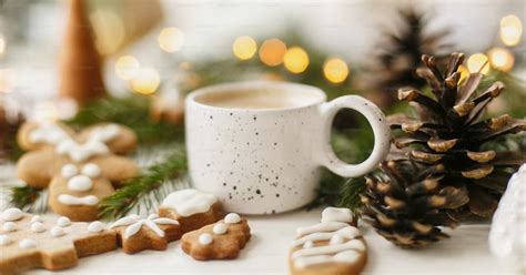 수제 진저 브레드 쿠키와 솔방울 장식 전나무 가지 흰색 나무 테이블에 따뜻한 조명이 있는 세련된 흰색 컵에 담긴 뜨거운 커피 안녕하세요 겨울 아늑한 변덕스러운 이미지