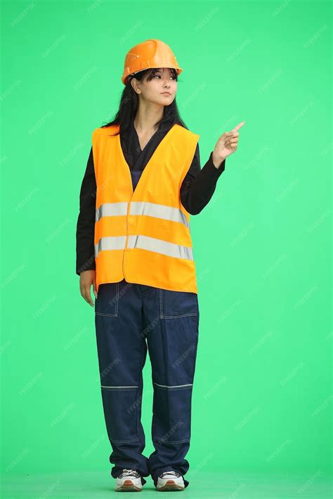 Premium Photo A Construction Worker Girl On A Green Background In