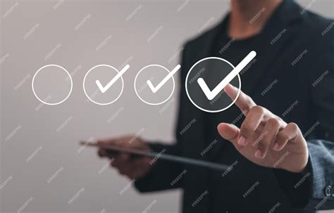 비즈니스맨은 가상 체크리스트를 만지고 품질 보장 및 Erp 관리를 승인하기 위해 온라인 평가 설문조사 테스트를 수행합니다 프리미엄 사진