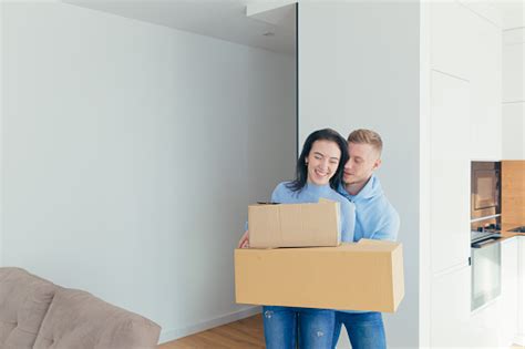 젊은 부부 남자와 여자는 상자와 물건과 함께 새 아파트로 이사 서로 를 놀라게 눈을 감고 미소 25 29세에 대한 스톡 사진 및 기타 이미지 Istock