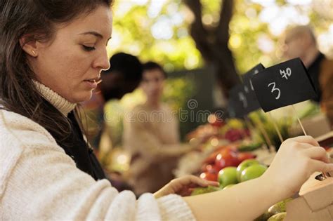Close Up Of Female Vendor Putting Price Tags For Every Product Stock