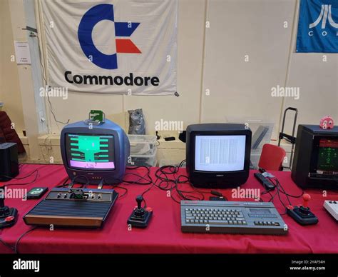Old Historic Vintage Commodore Computers With Monitors On Display On A Red Table At The Hcc