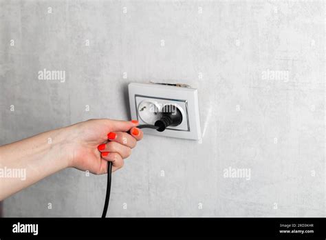 The Girl Incorrectly Removes The Electric Plug From The Socket And