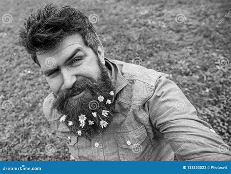 Hipster On Winking Face Sits On Grass Defocused Man With Beard Enjoys Spring Green Meadow