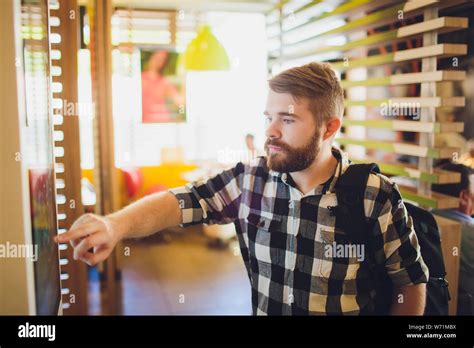 A Man Orders Food In The Touch Screen Terminal With Electronic Menu In Fast Food Restaurant