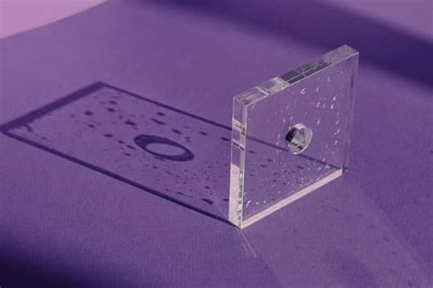 A Light Casting A Rectangular Shadow Of A Square Glass With Water