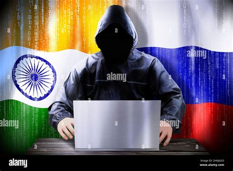 anonymous hacker working on a laptop flags of india and russia stock