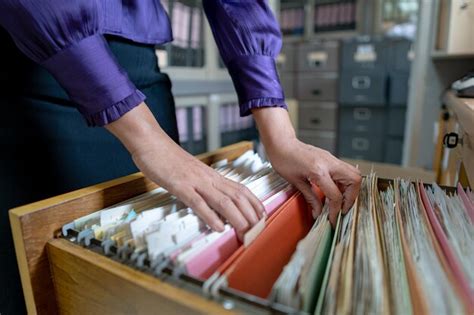 Premium Photo Midsection Of Woman Removing File At Office