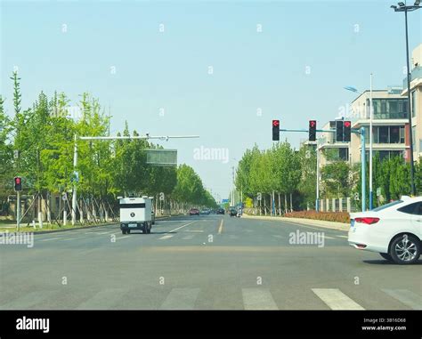 Autonomous Delivery Vehicle Stopping At Traffic Light In Modern Chinese Urban Environment