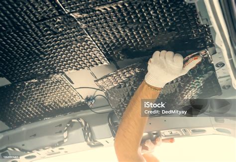 Worker Installation Soundproofing Material To Inside Of Car Roof Sound