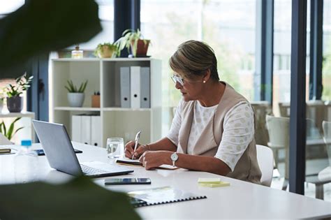 시니어 비즈니스 우먼 계획을 위한 글쓰기와 노트북 스타트업 사무실에서 노트북으로 일정에 맞춰 목표를 달성합니다 Ceo 목표 비전