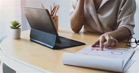 컴퓨터 태블릿으로 작업하고 책상에서 재무 보고서를 분석하는 사업가의 잘린 샷 사진 Unsplash의 태국 이미지