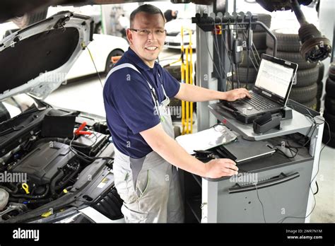 car mechanic maintains a vehicle with the help of a diagnostic computer - modern technology in ...