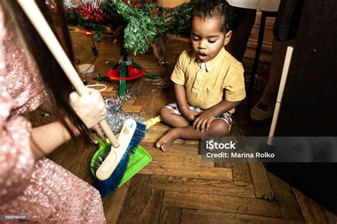 흑인 소년은 바닥에 앉아 어떻게 그의 어머니가 깨진 장난감 걸레 크리스마스 트리에서 외모 가족 백인 어머니와 흑인 아이들 집에서 검은 아이 가정 장식 아이 크리스마스 함께