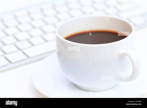 White Cup Of Coffee Presented In Front Of Computer Keyboard Stock Photo Alamy