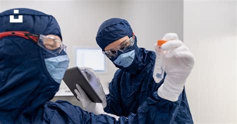 태블릿을 사용하여 수술 용 스크럽 및 마스크를 착용 한 소수의 사람들 사진 Unsplash의 무료 코 비드 19 이미지