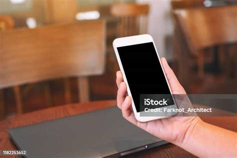 테이블에 노트북 컴퓨터와 빈 데스크톱 화면 흰색 휴대 전화를 들고 손의 모형 이미지 가득 찬에 대한 스톡 사진 및 기타 이미지 가득 찬 공란 노트북 Istock