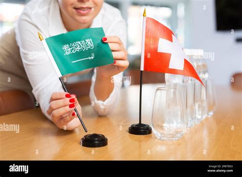 Little Flag Of Switzerland On Table And Flag Of Saudi Arabia Put Next