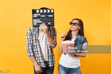 젊은 커플 여자 남자 만들기 Clapperboard 지주 양동이 팝콘 노란색 배경에 고립의 고전 흑인 영화로 얼굴을 덮고 날짜에 영화 영화를 보고 3d 안경에서 극장에서의